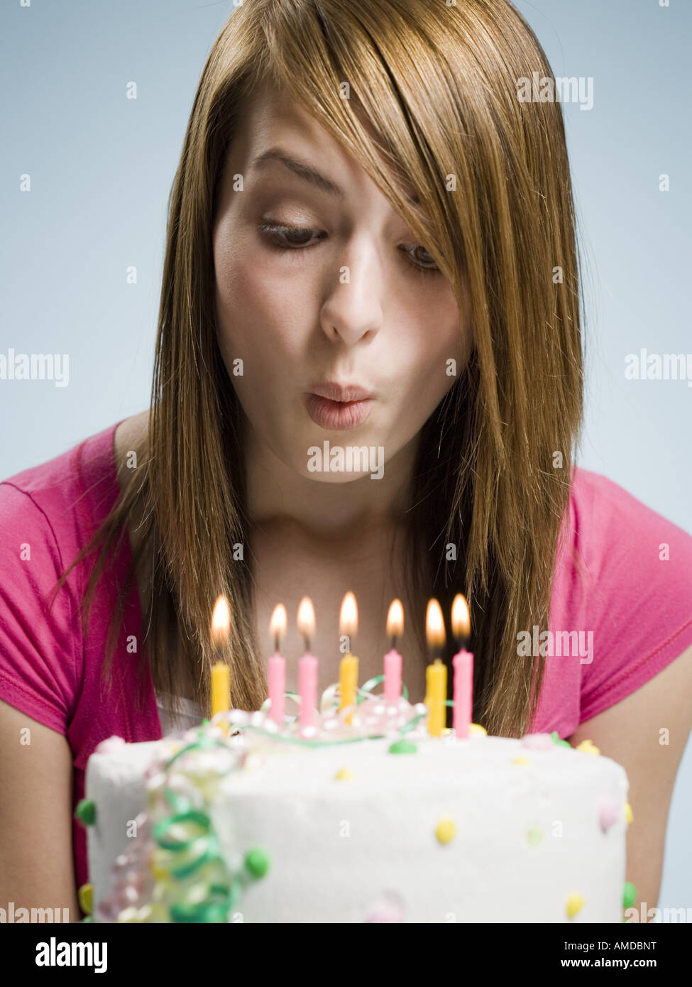 Woman blowing out candles on a birthday cake Stock Photo - Alamy