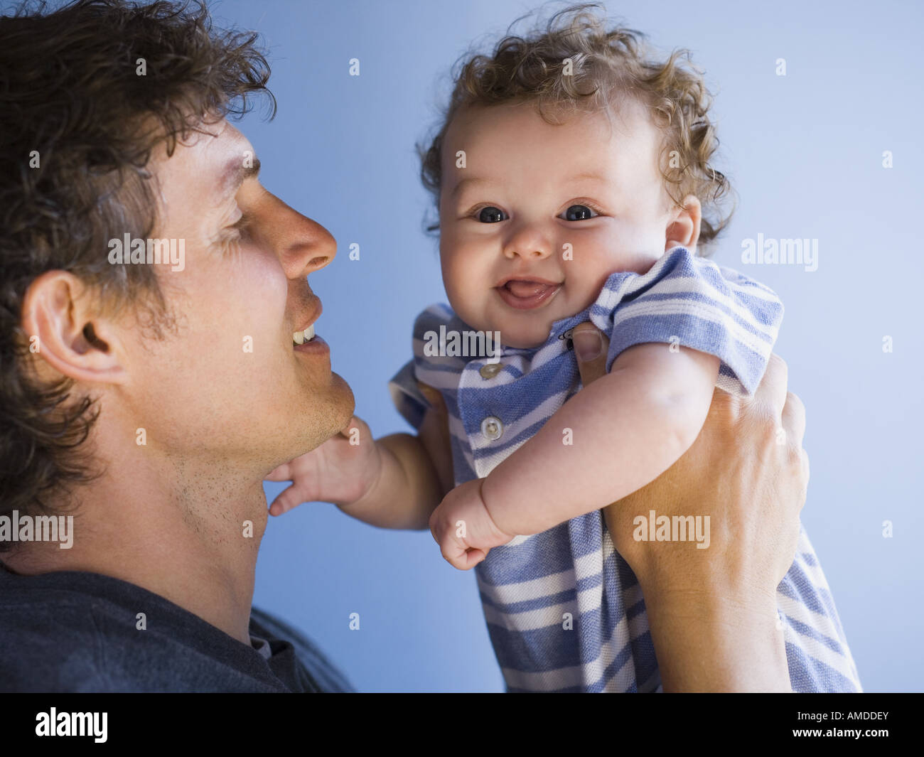 Man holding baby boy smiling Stock Photo - Alamy