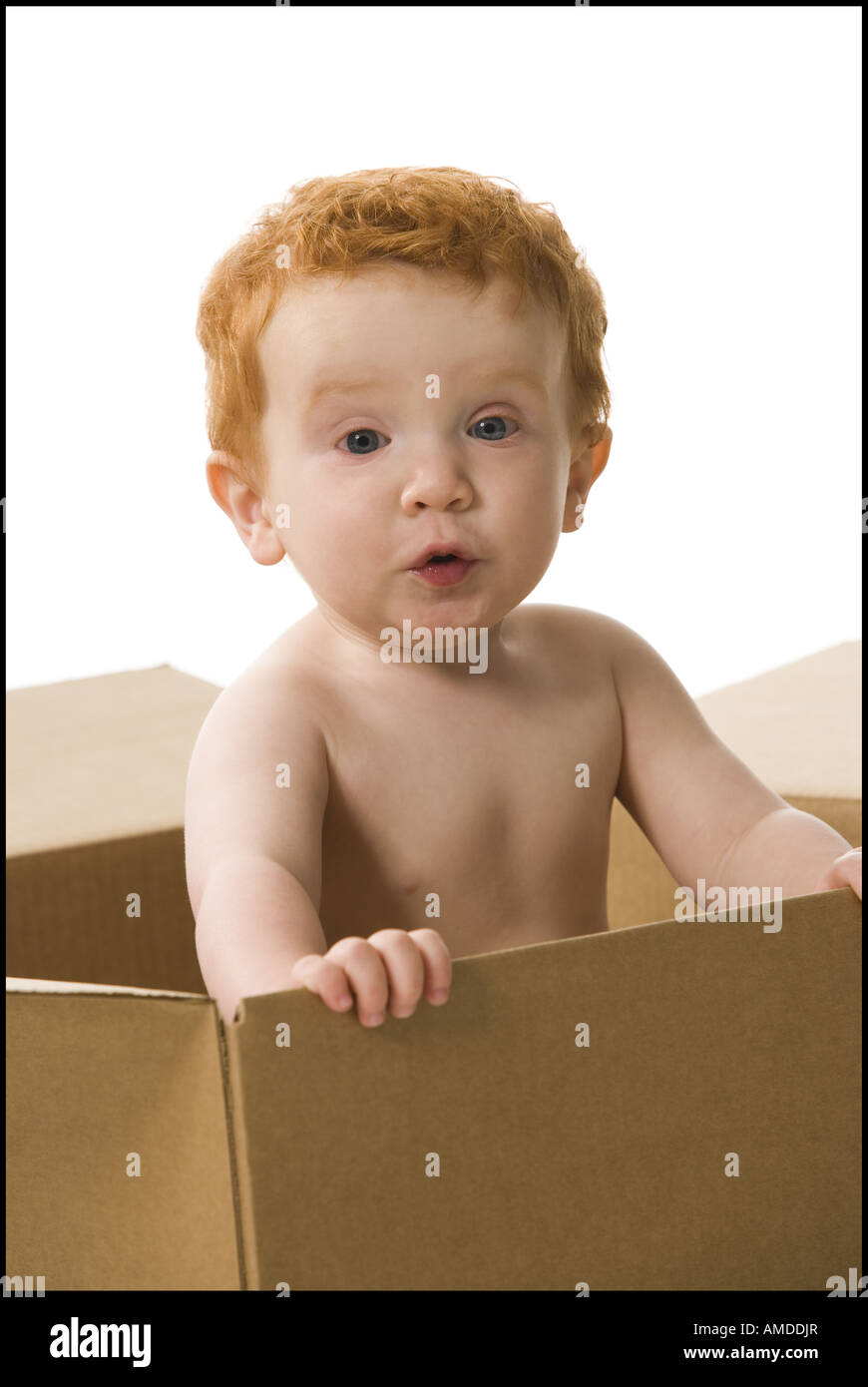 Baby boy in cardboard box making funny face Stock Photo - Alamy