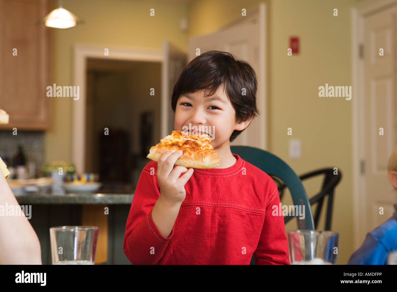 Portrait of a boy eating pizza Stock Photo - Alamy