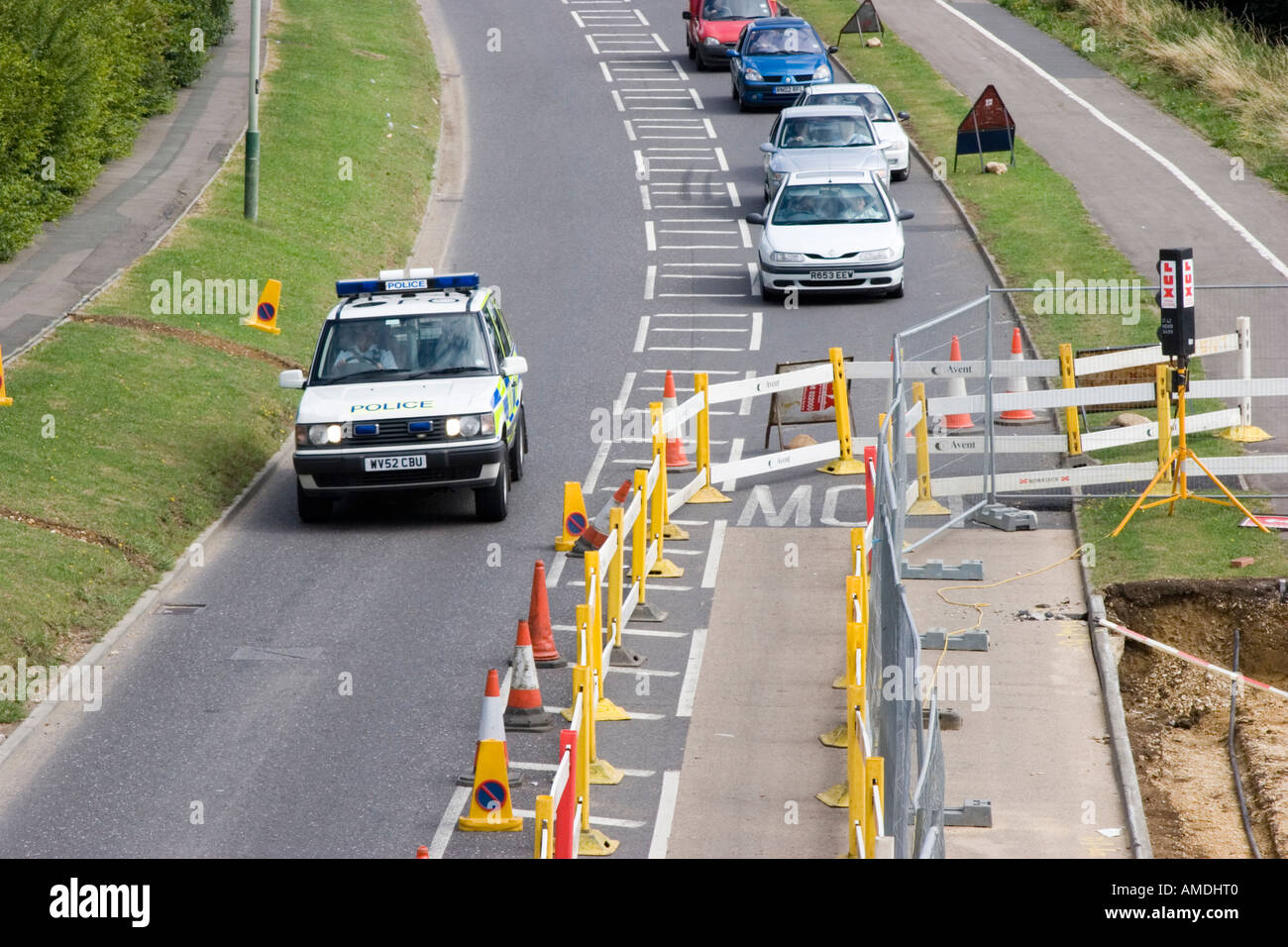 A police land rover races to an emergency through roadworks and traffic ...