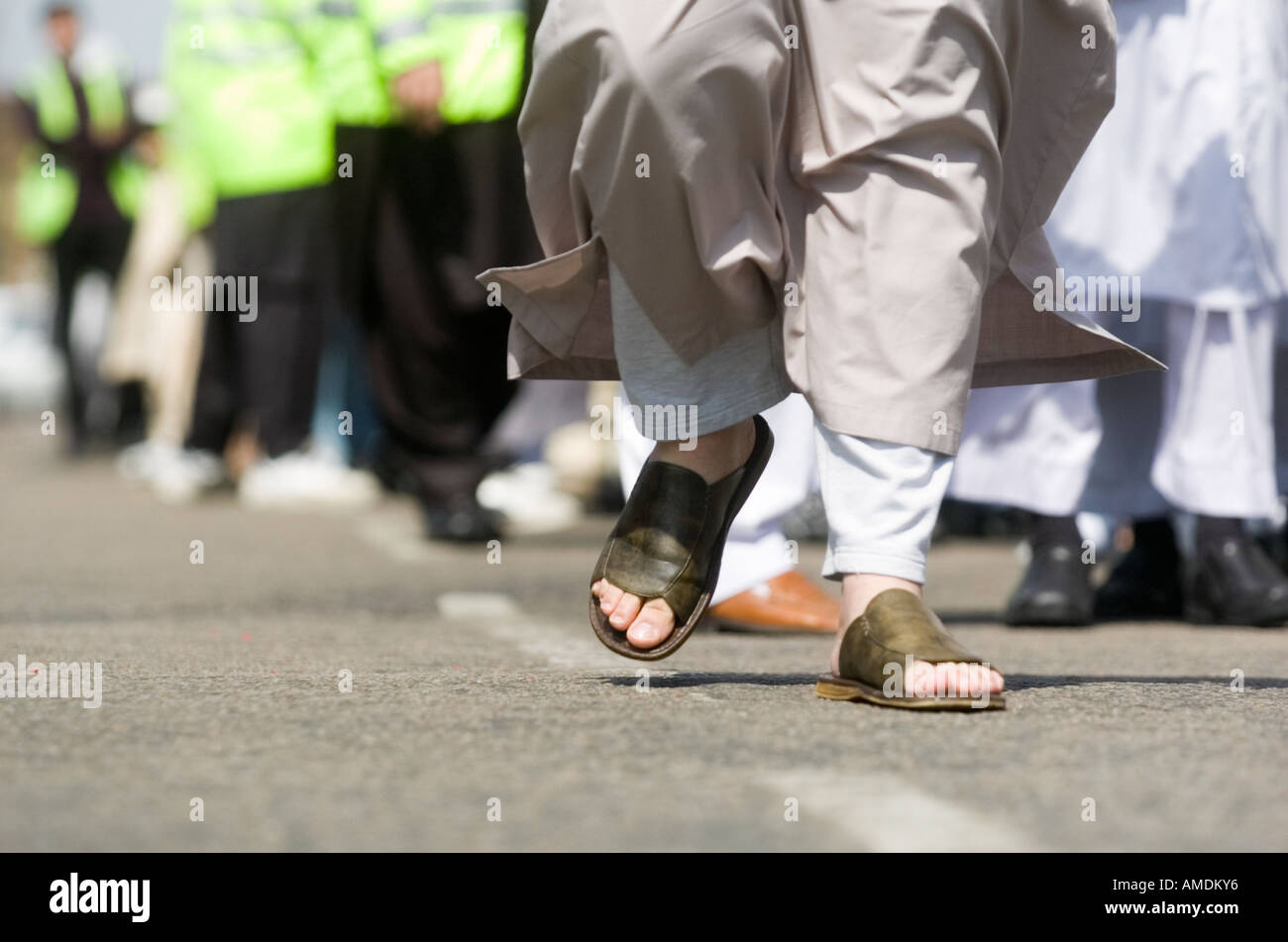 A man wearing sandals walking on a tarred road in a peaceful protest ...