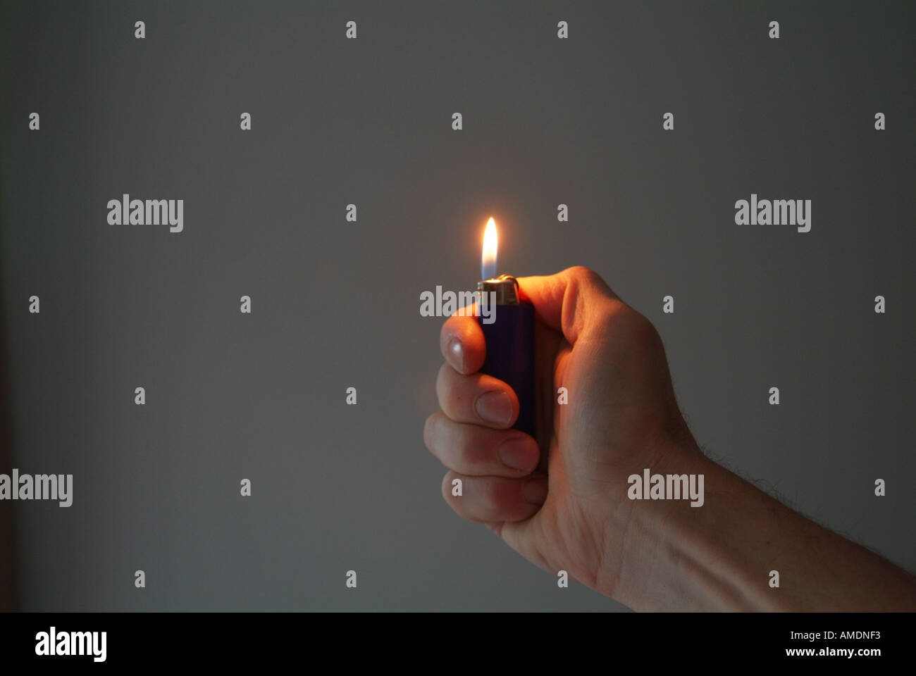 Hand holding lit cigarette lighter Stock Photo - Alamy