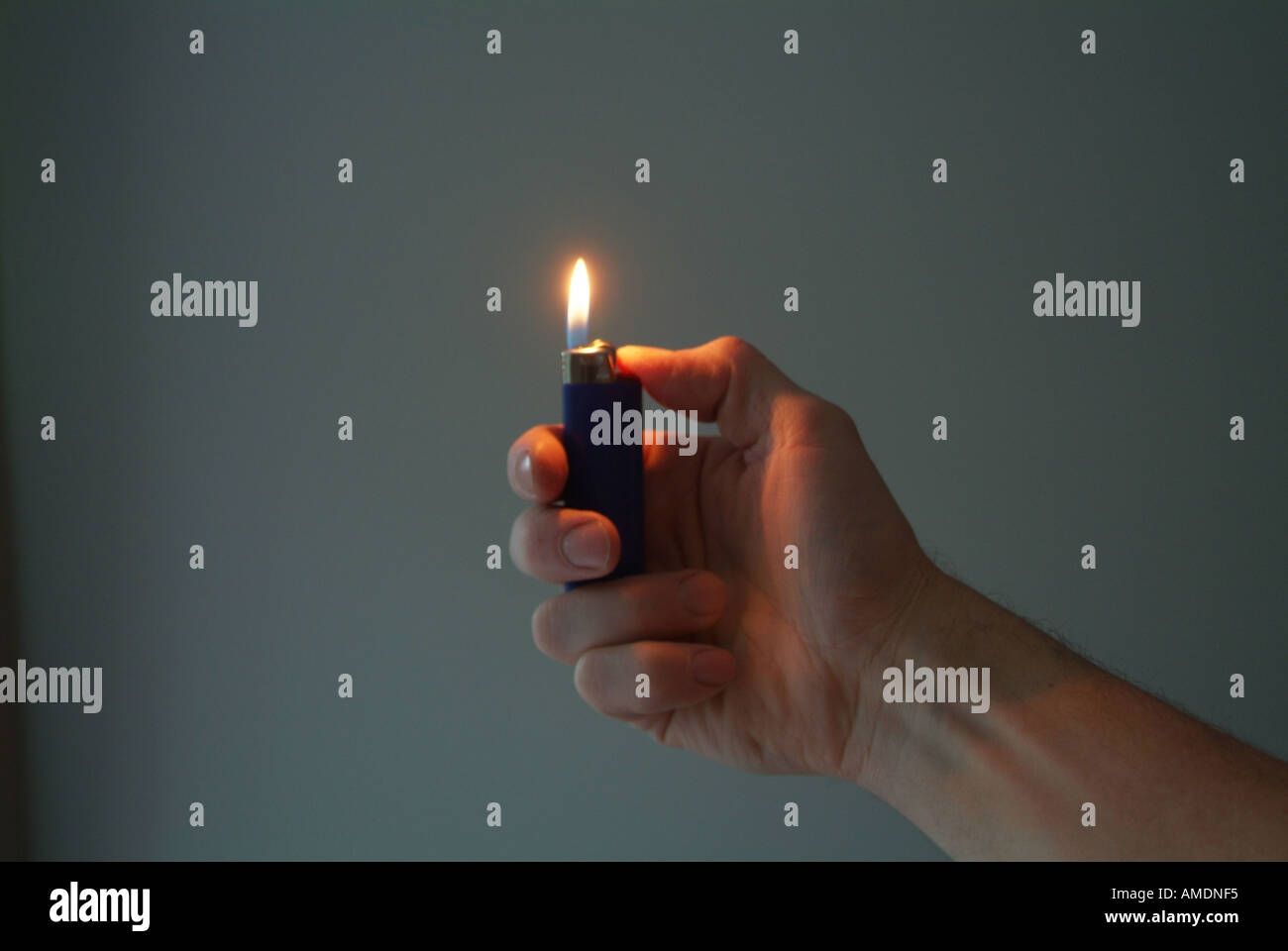 Hand holding lit cigarette lighter Stock Photo - Alamy