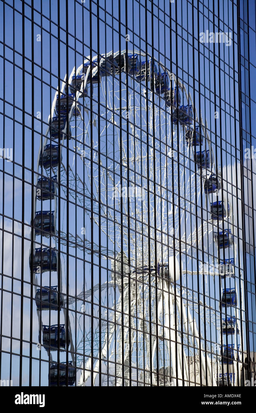 A giant ferris wheel reflected in the glass front of the Hyatt hotel in ...