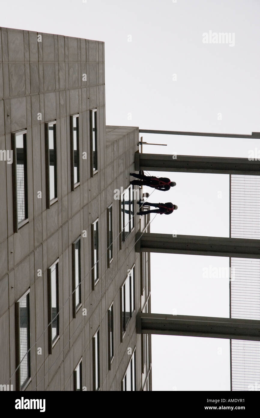 two people abseiling down the side of a tall building Stock Photo - Alamy