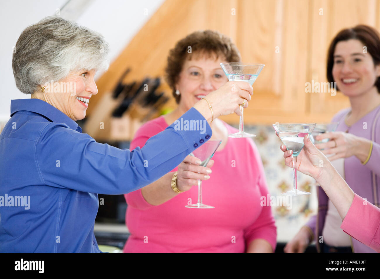 Women toasting with drinks in a kitchen Stock Photo - Alamy