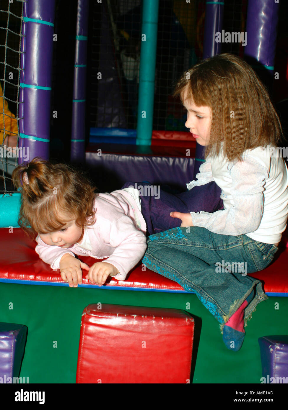 Sisters playing together in soft play area Stock Photo - Alamy