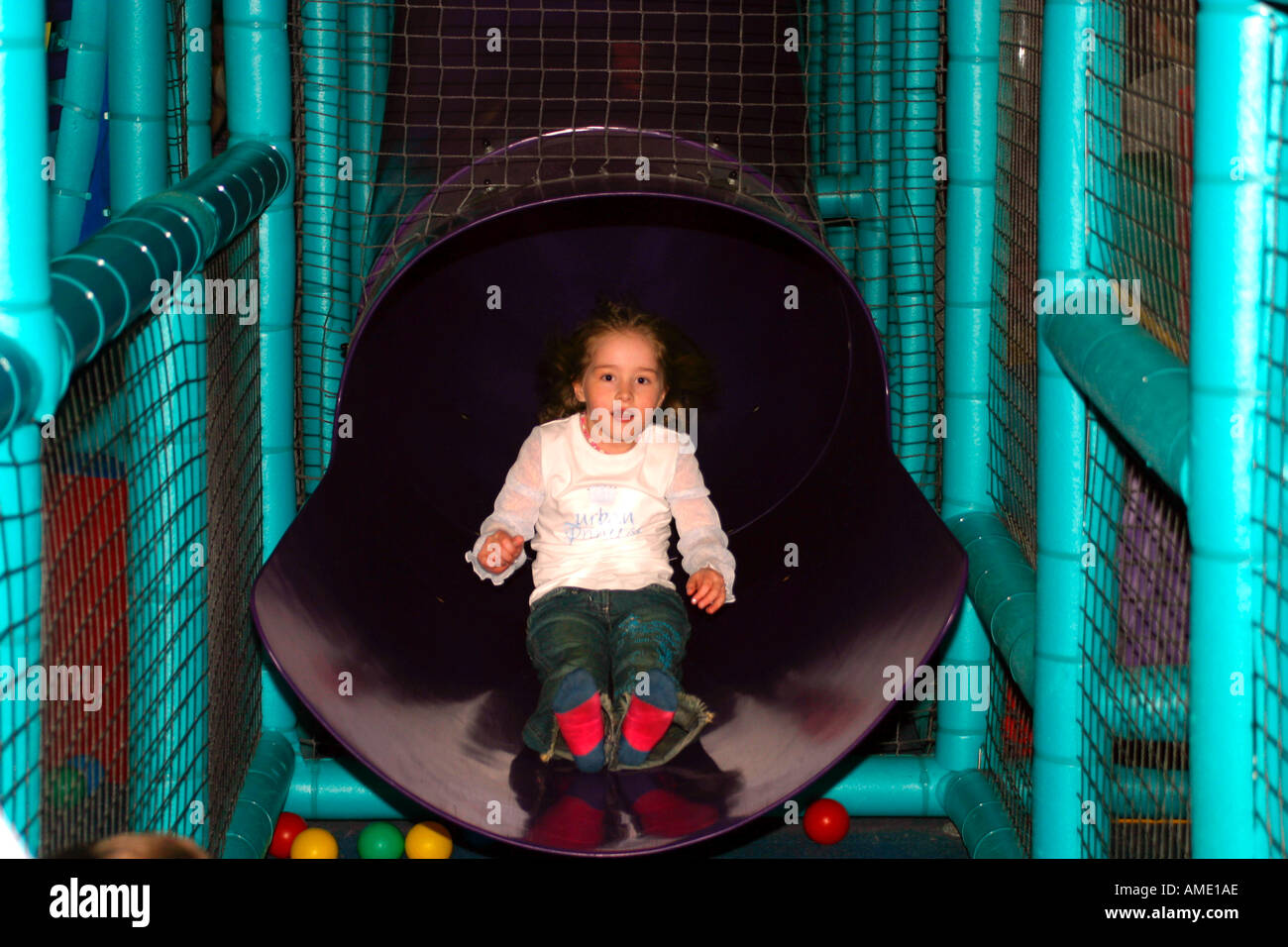 Young girl playing on slide in soft play area Stock Photo - Alamy