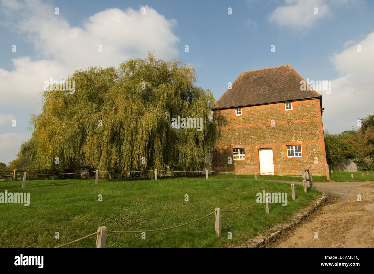 Brick built mill with willow tree Stock Photo - Alamy