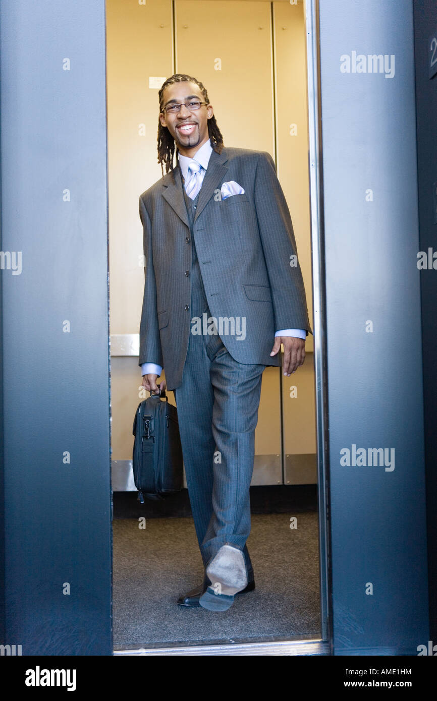 A young man stepping out of the elevator Stock Photo - Alamy