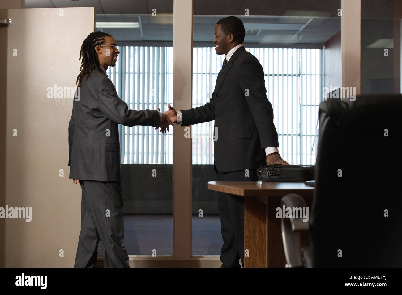 View of businessmen shaking hands in an office Stock Photo - Alamy