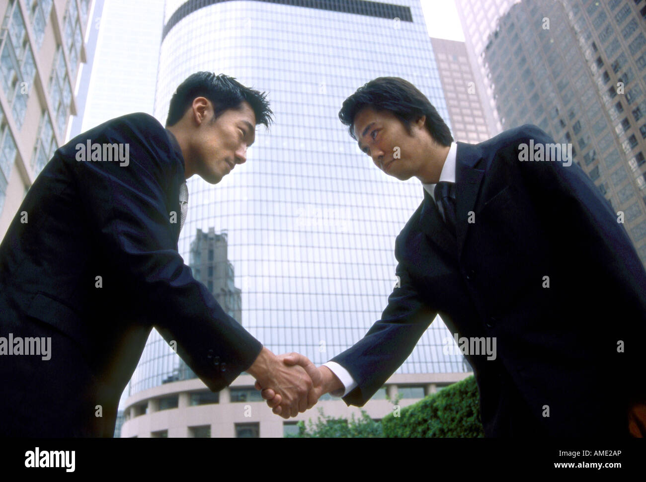 Japanese Businessmen Bowing and Shaking Hands Stock Photo - Alamy
