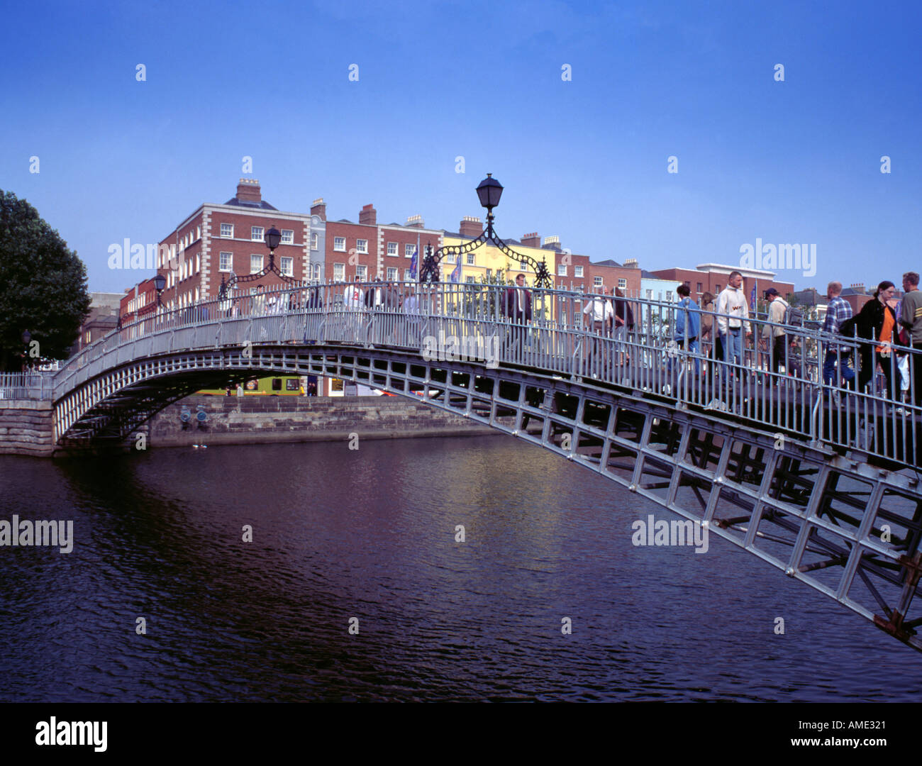 People crossing the picturesque cast iron Ha'penny Bridge over the ...