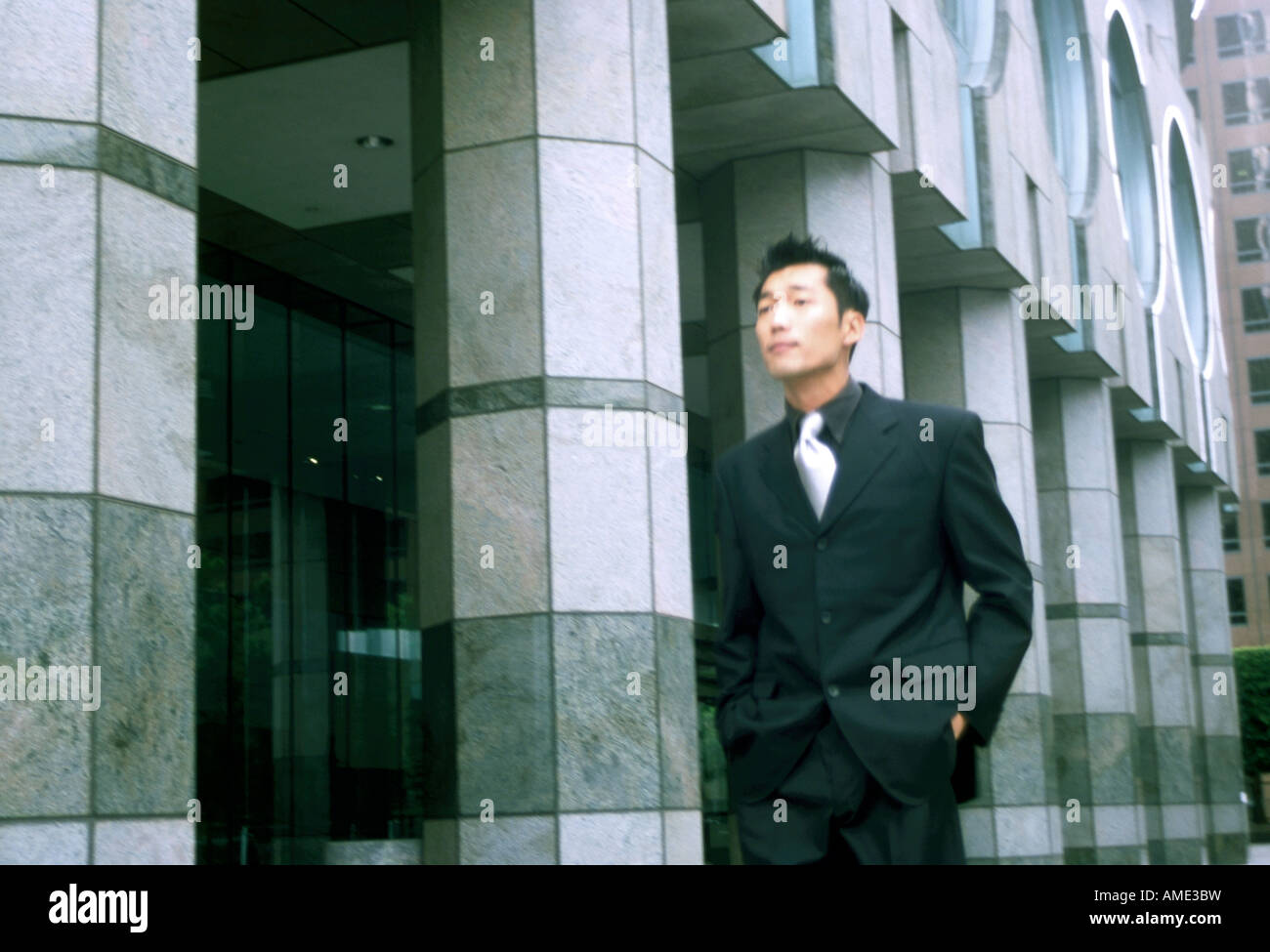 Businessman Walking Past Building Stock Photo - Alamy