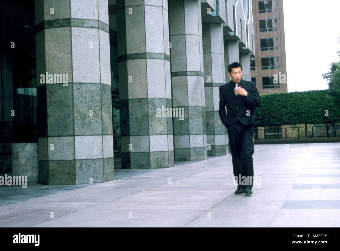 Businessman Walking Past Building Stock Photo - Alamy