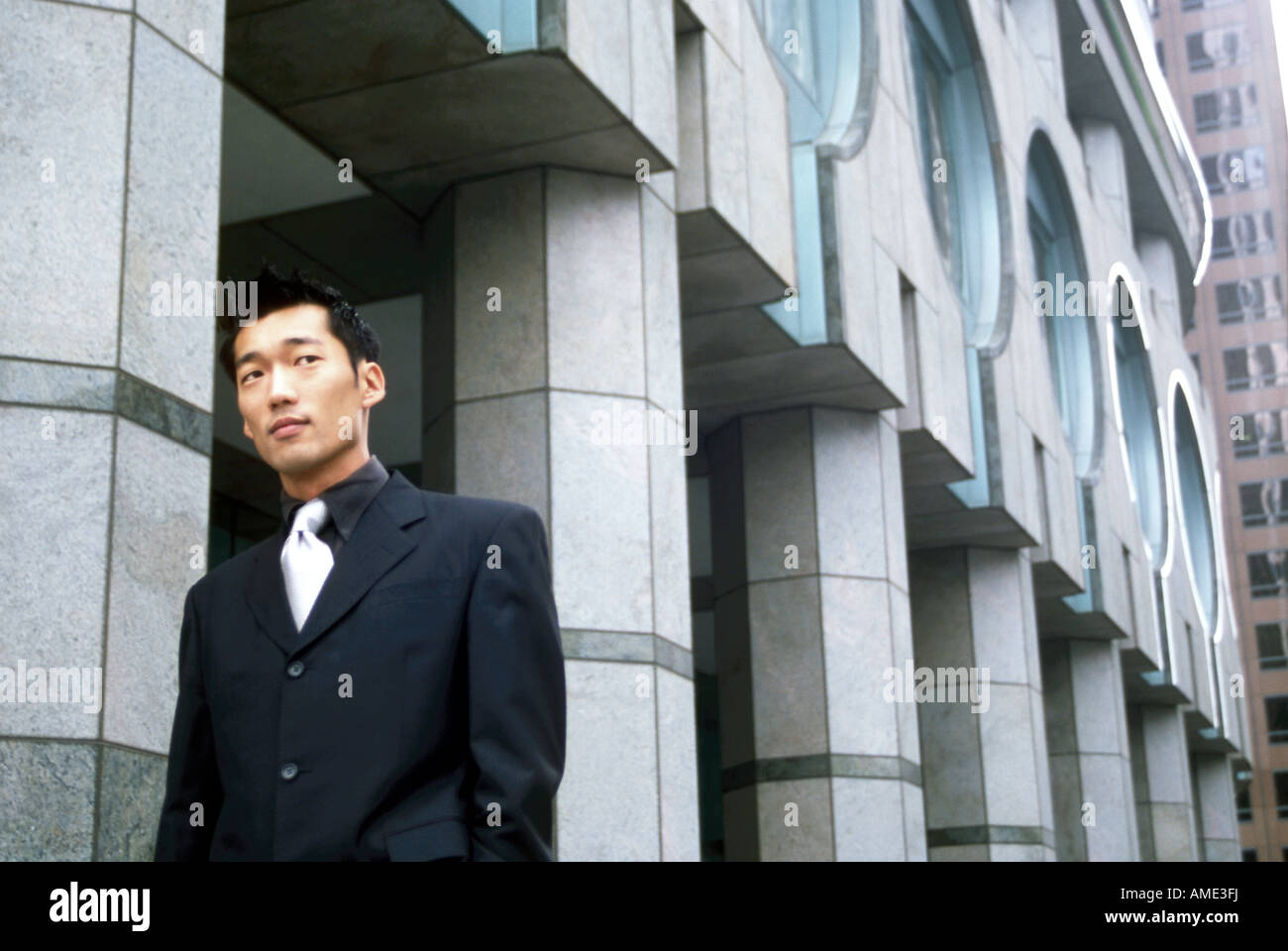 Businessman Walking Past Building Stock Photo - Alamy