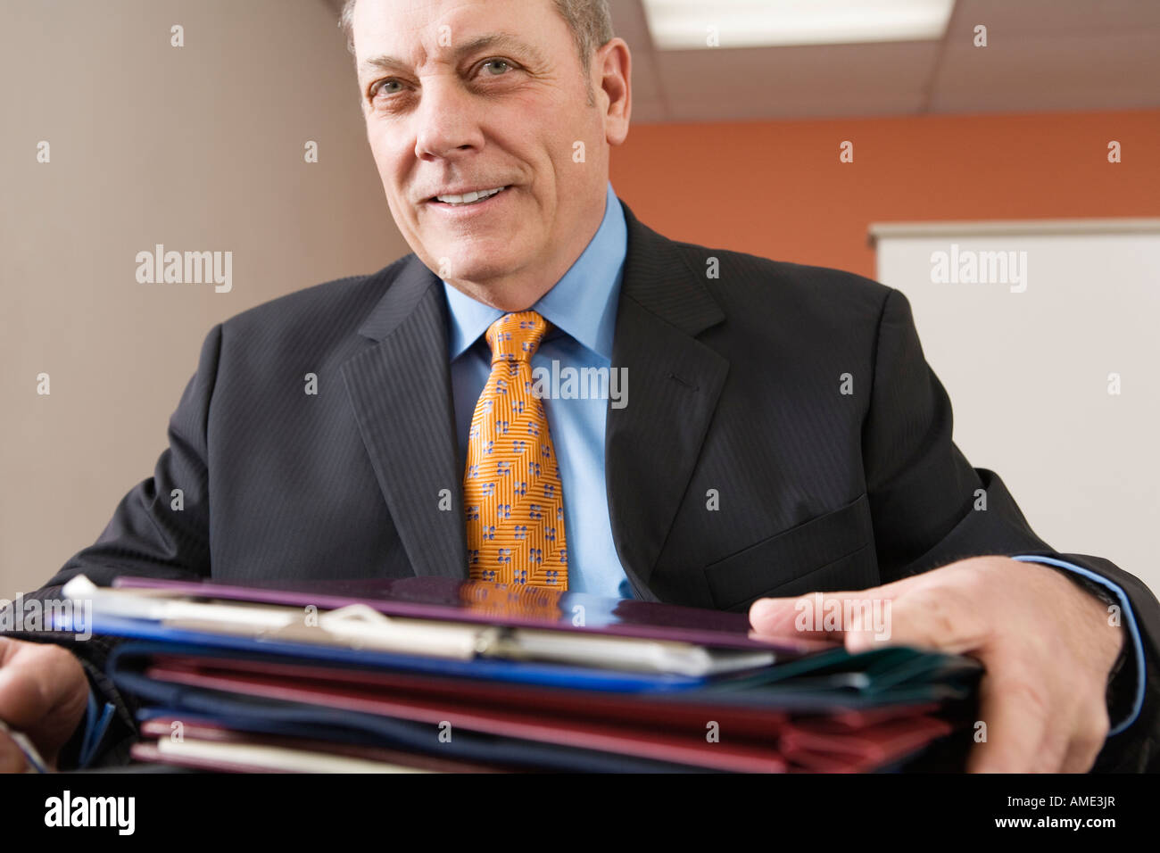View of a businessman sitting with files in office Stock Photo - Alamy