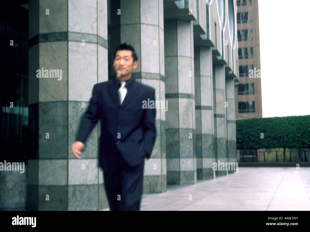 Businessman Walking Past Building Stock Photo - Alamy