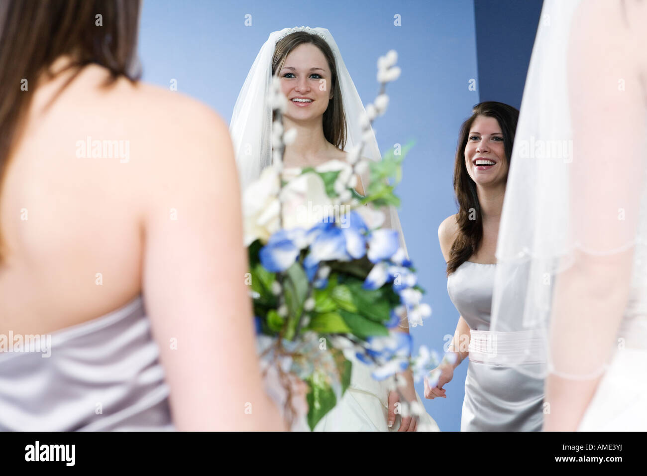 Bride with her bridesmaid looking in mirror Stock Photo - Alamy