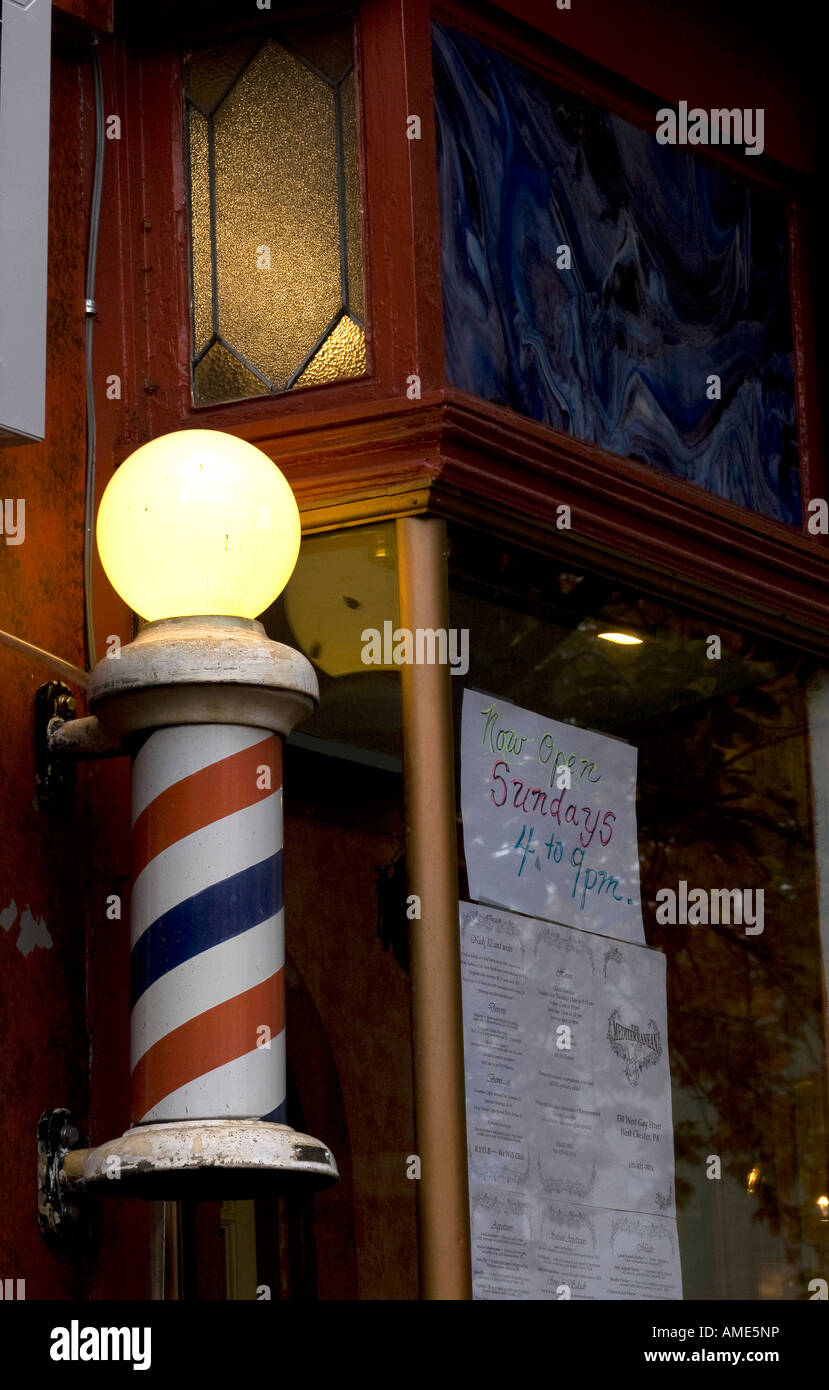 A Barber shop pole spinning in town Stock Photo - Alamy