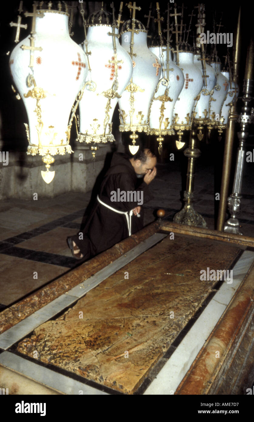 A friar prays on the Stone of the Unction where Christ is believed to ...