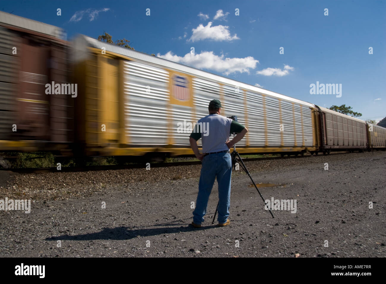 Train speeds past cameraman under blue skies Stock Photo - Alamy