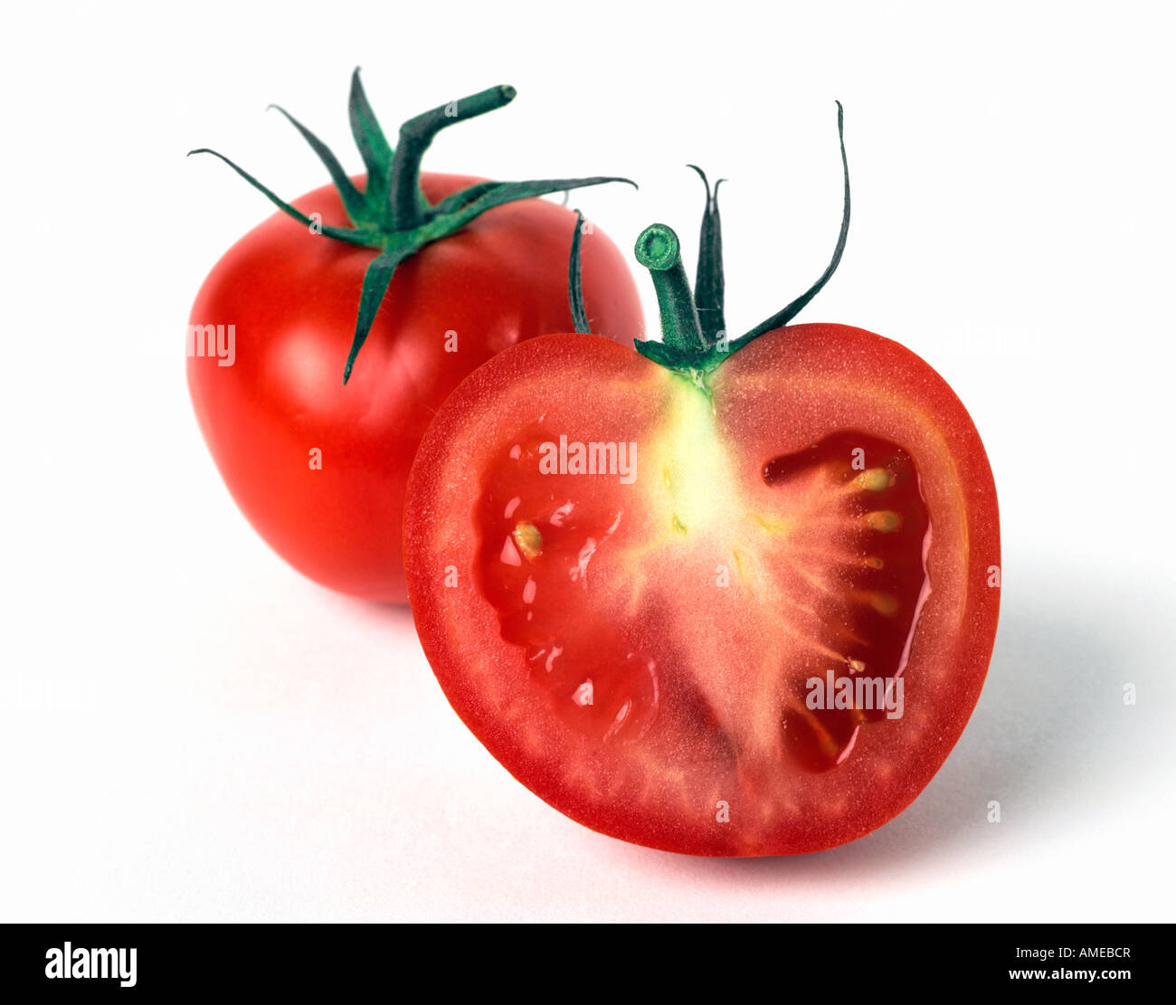 Closeup of a cross section and whole Tomato on a white background Stock ...