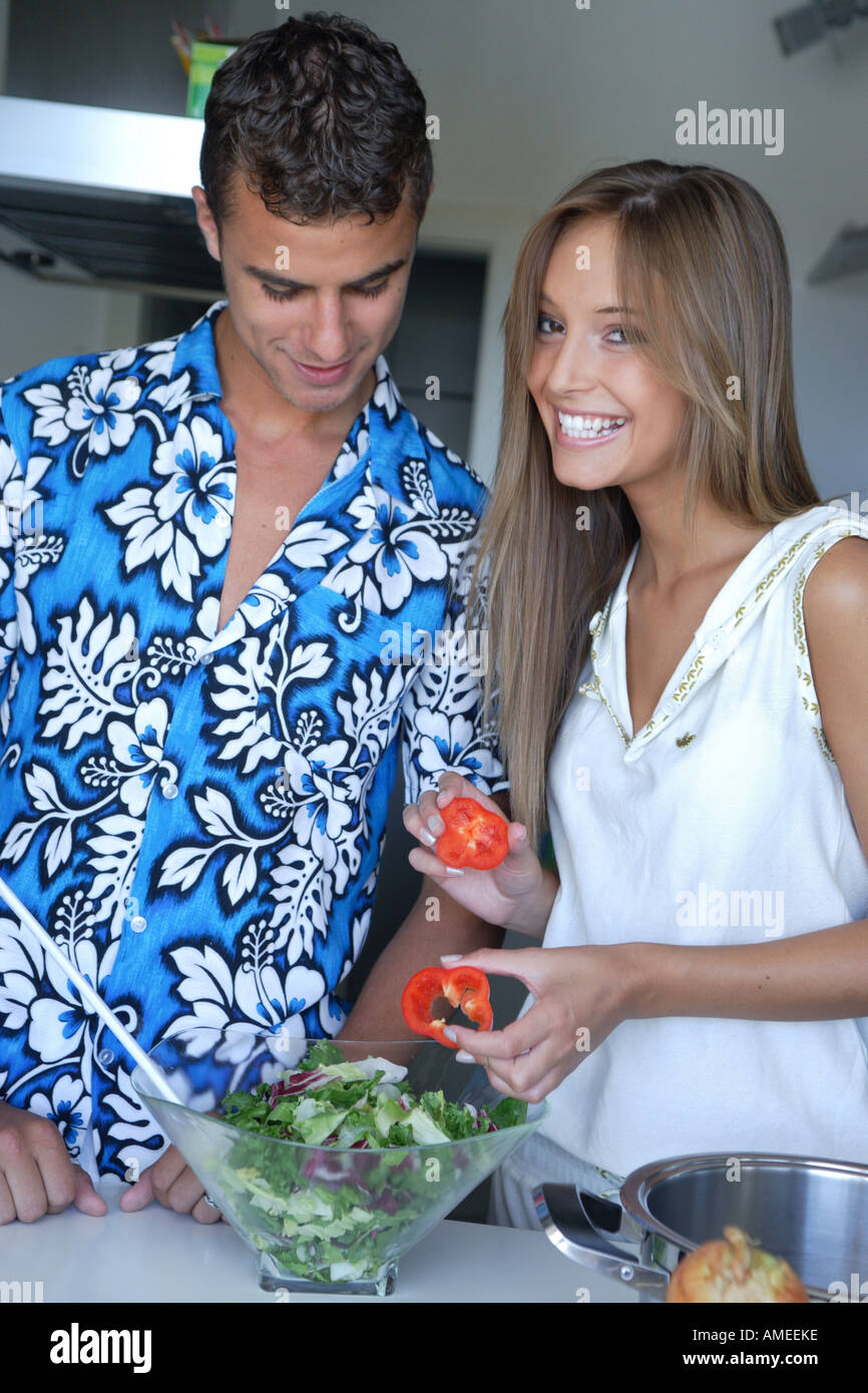 young couple dressing salad in the kitchen Stock Photo - Alamy