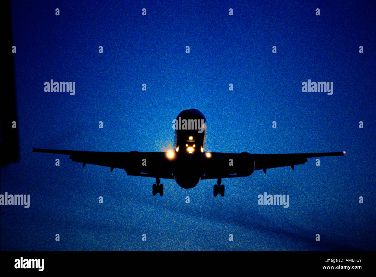 commercial jet landing with lights at dusk Stock Photo - Alamy