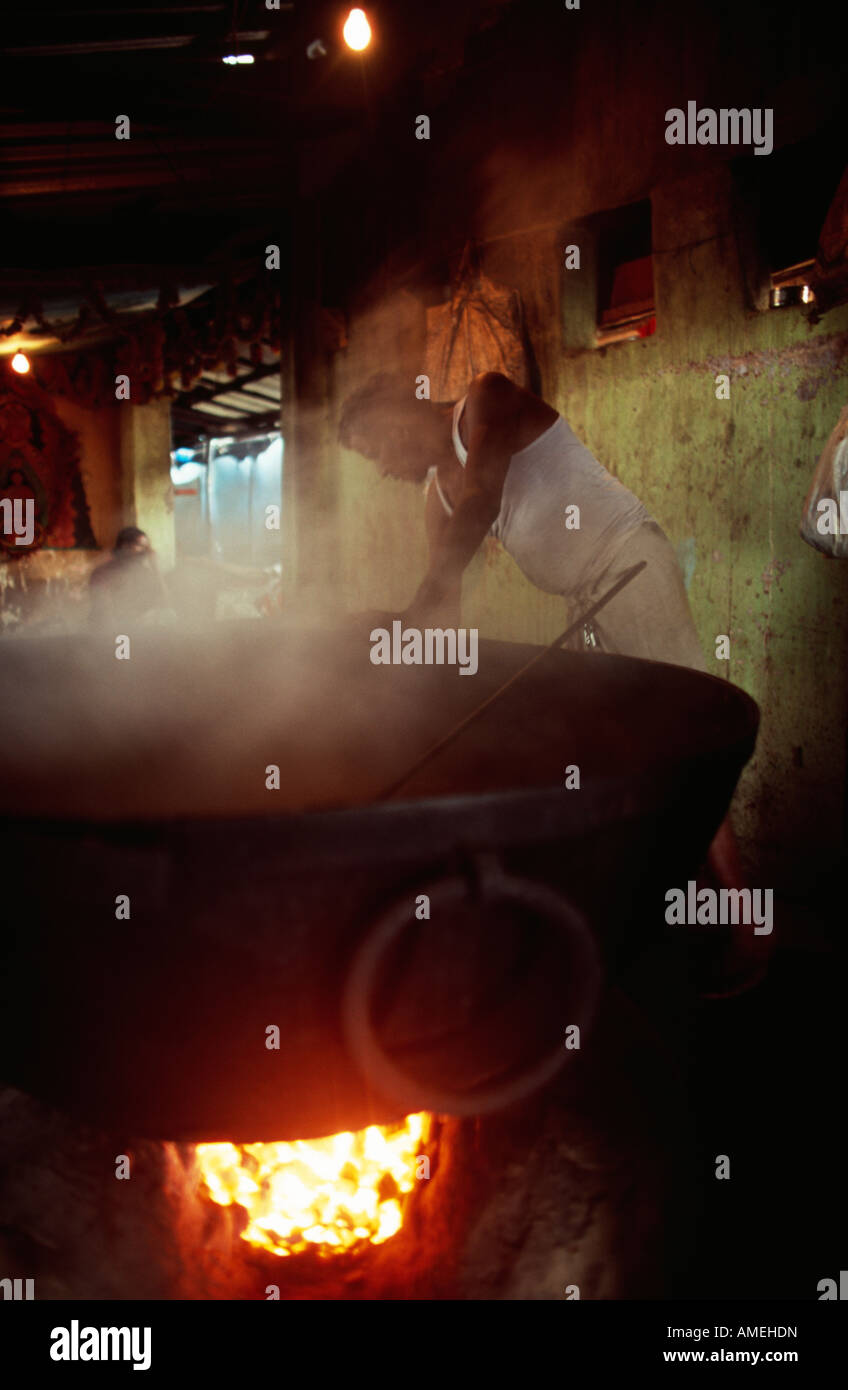 Man cooking in a large pot at the temple under the Howrah Bridge ...