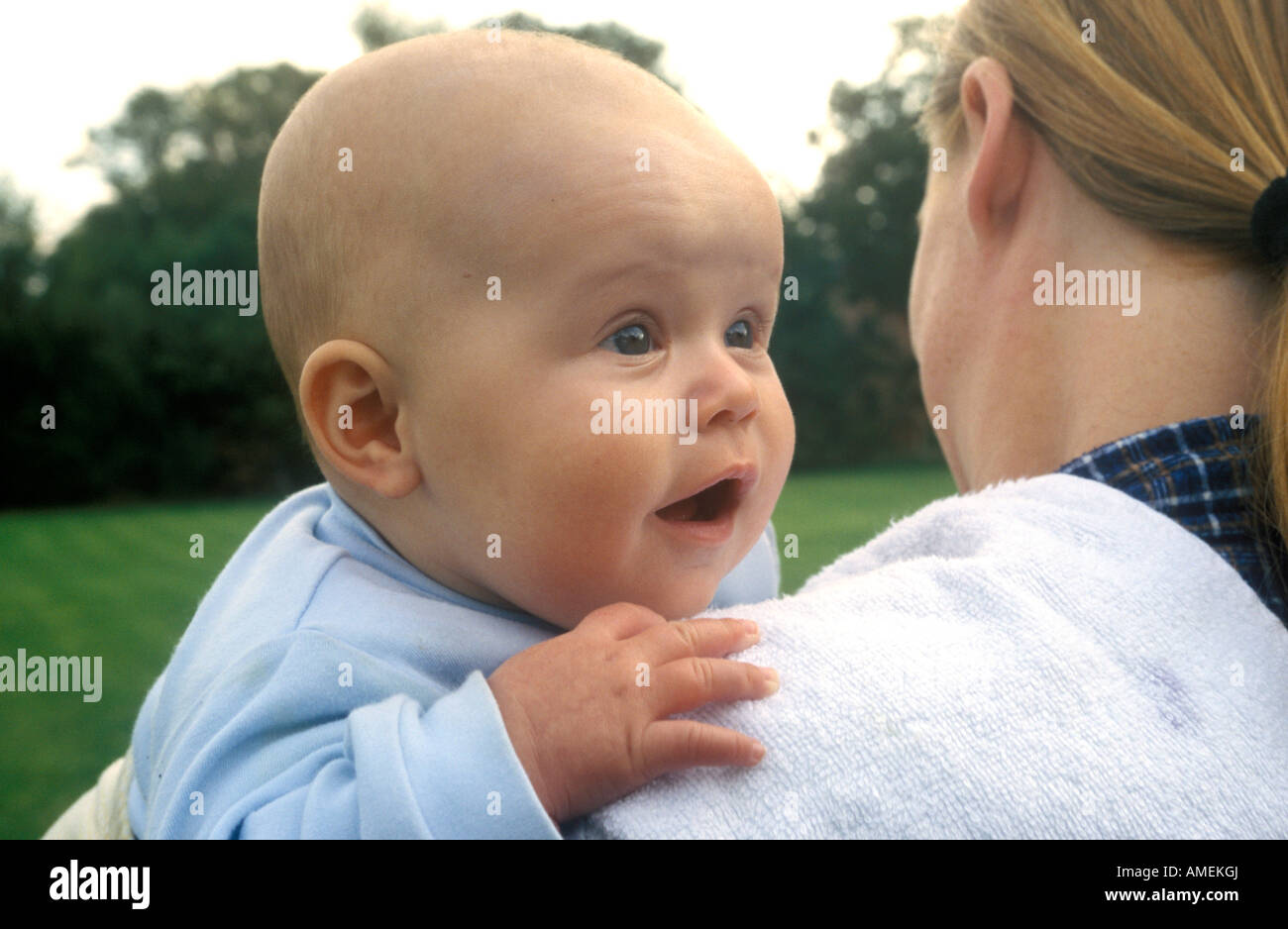 baby girl with her eyes and mouth wide open resting on her mother´s ...