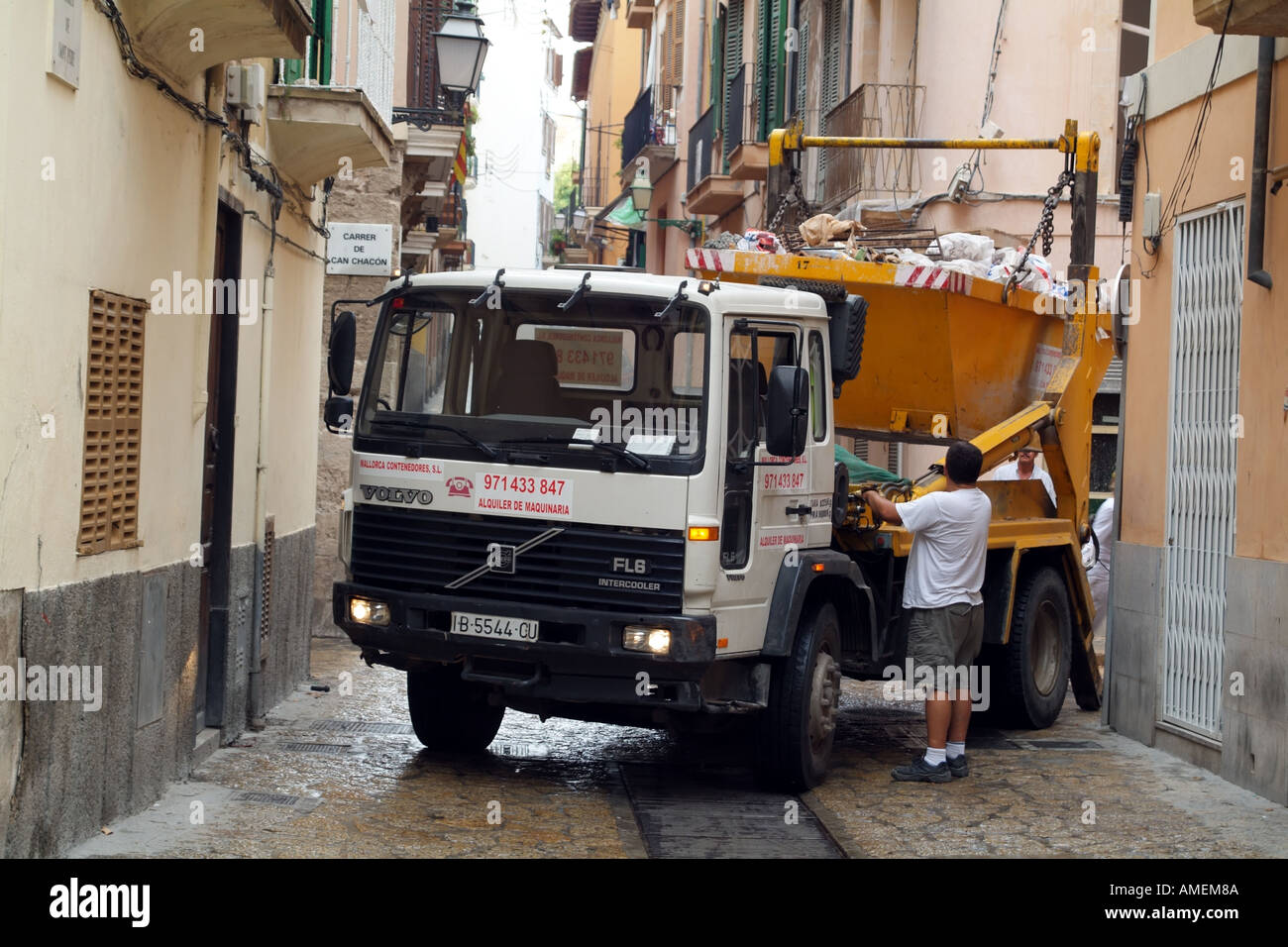 builders skip loading rubble rubbish lorry on narrow street Stock Photo ...