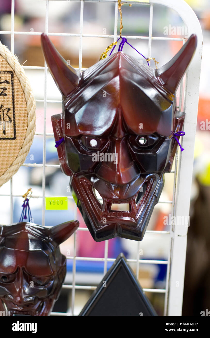 Wood Kabuki mask reddish stain hanging on a white rack Stock Photo - Alamy