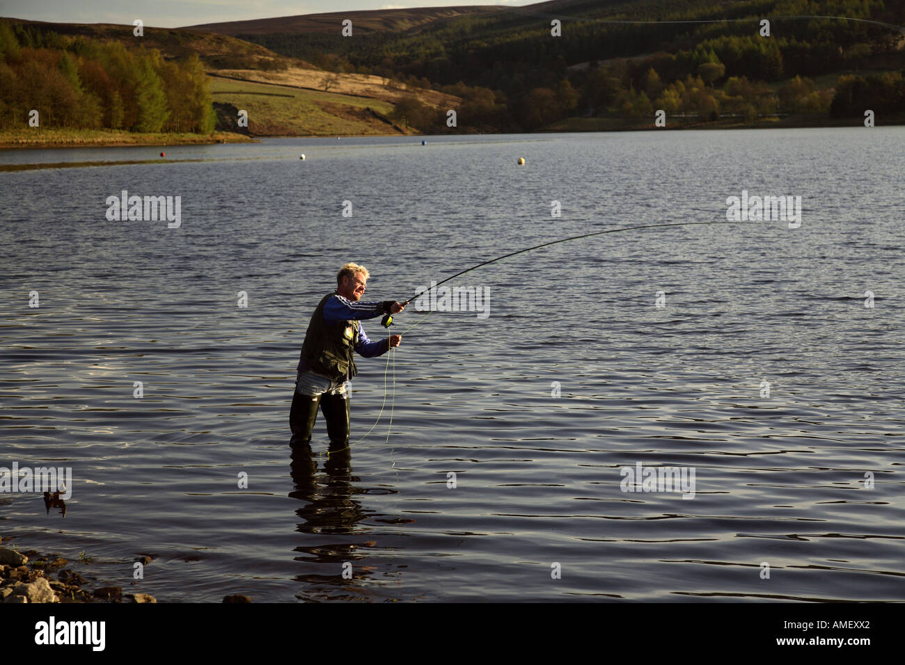 Man fishing on the Errwood Reservoir in the Goyt Valley in the Peak ...