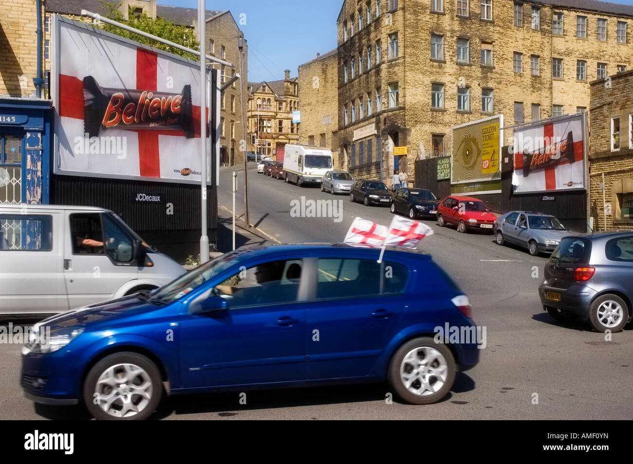 An car with two England flags driving past two roadside advertisements ...