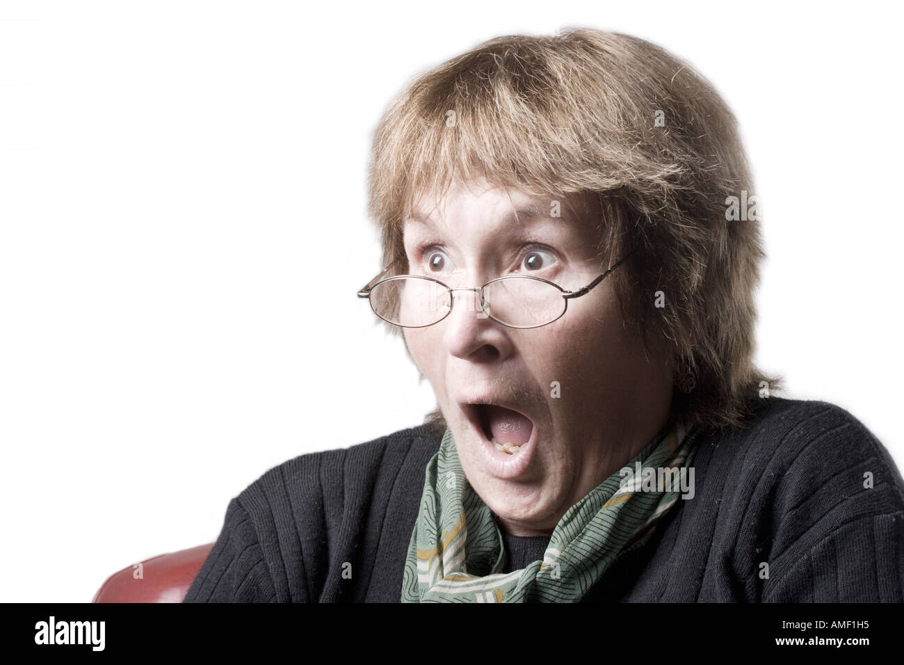Portrait of a middle age woman with a shocked face sitting down in a ...