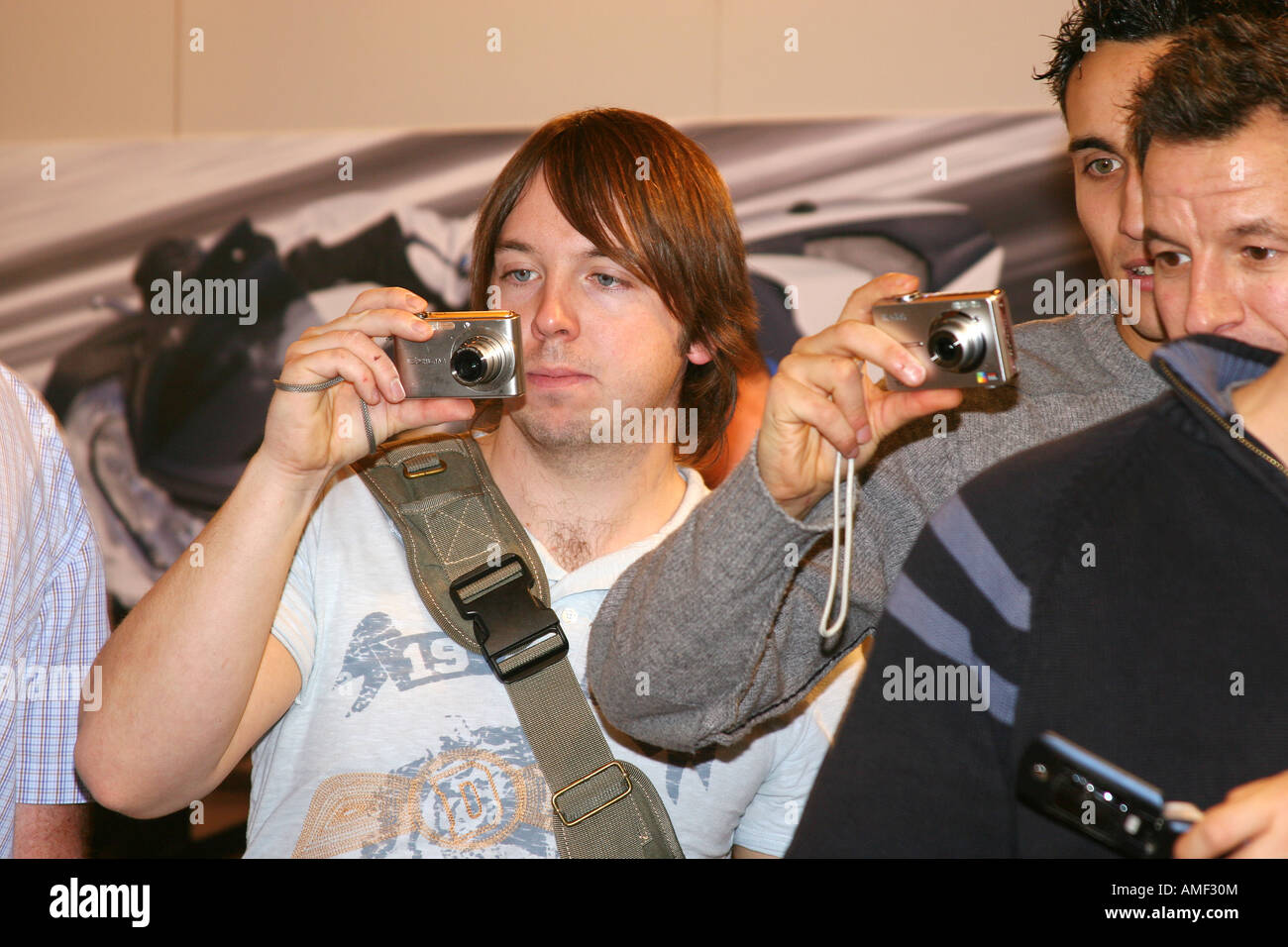 People holding modern tiny digital compact cameras at arms length in ...