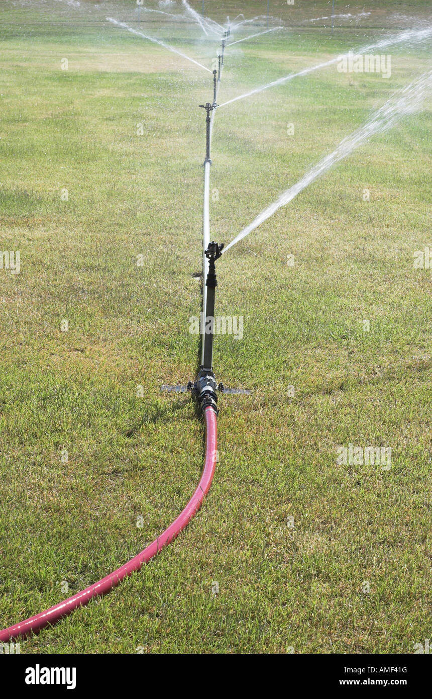 An irrigation system spraying water over a sports field to maintain the ...