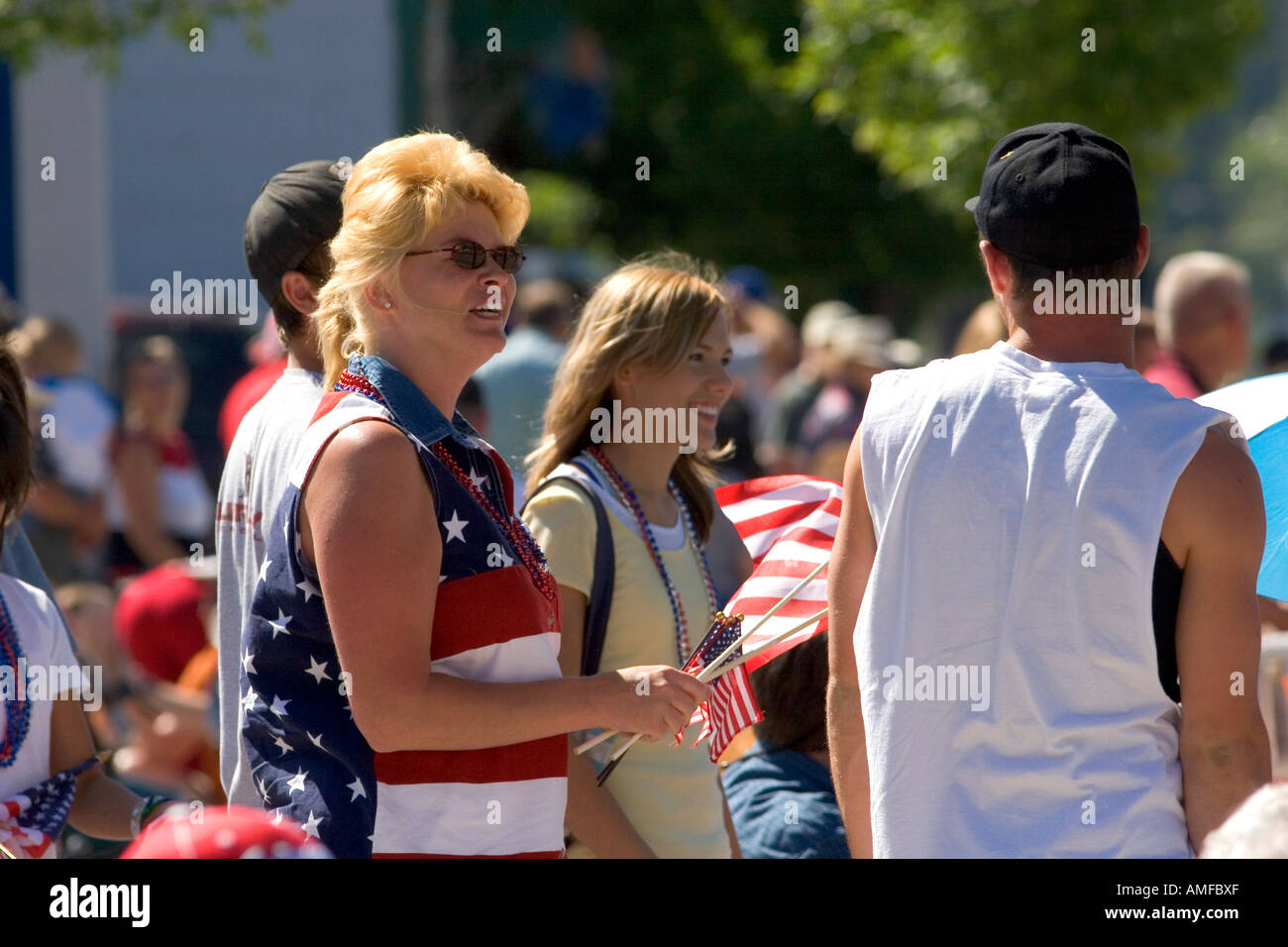 A patriotic woman watching a small town Fourth of July parade in ...
