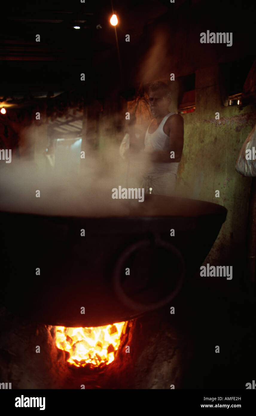 Man cooking in a large pot at the temple under the Howrah Bridge ...