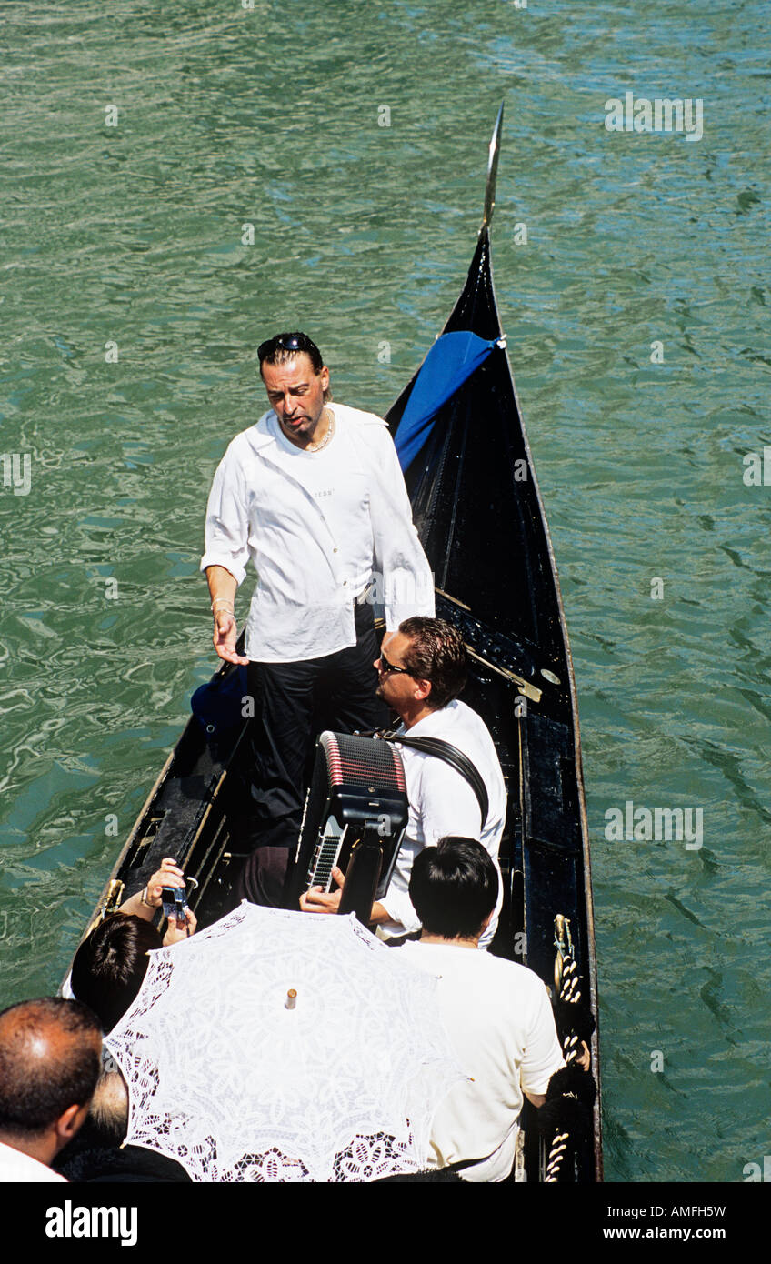 Tourists, singer, and musician in a gondola, on the Grand Canal, Venice ...