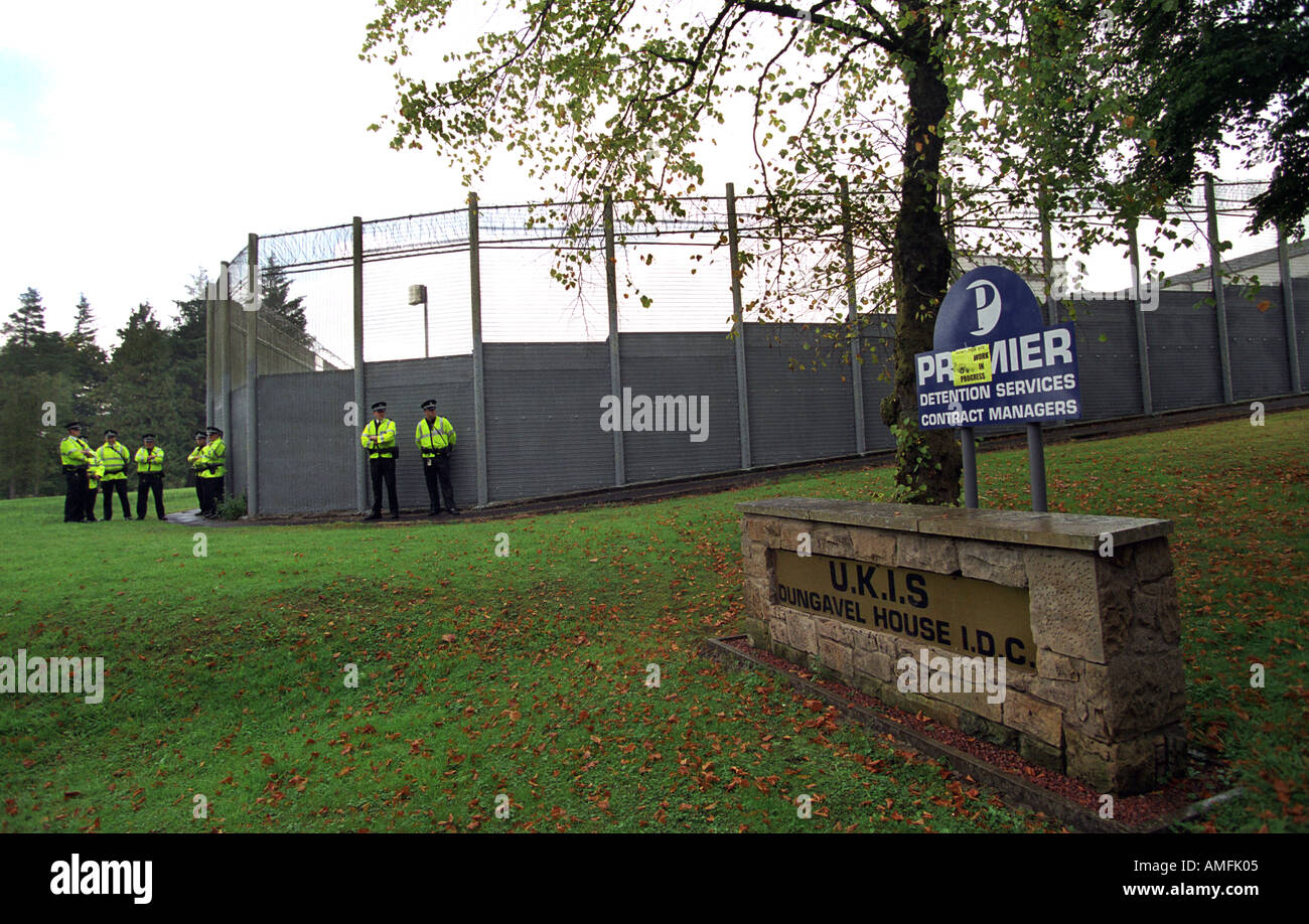 Police outside the barbed wire fence of the Dungavel dentention centre ...