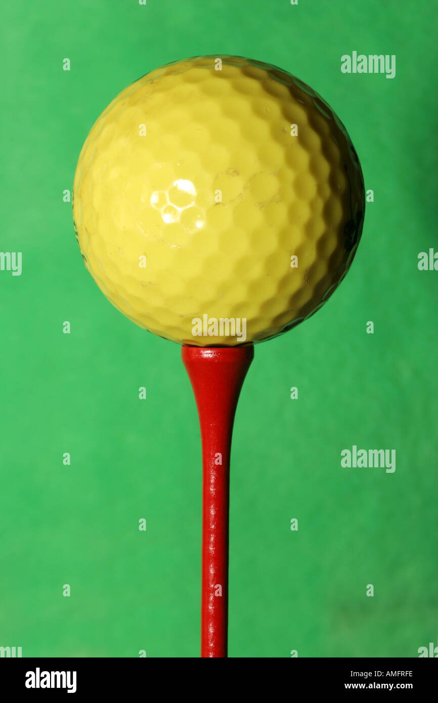 A yellow golf ball on a red peg against a green background Stock Photo ...