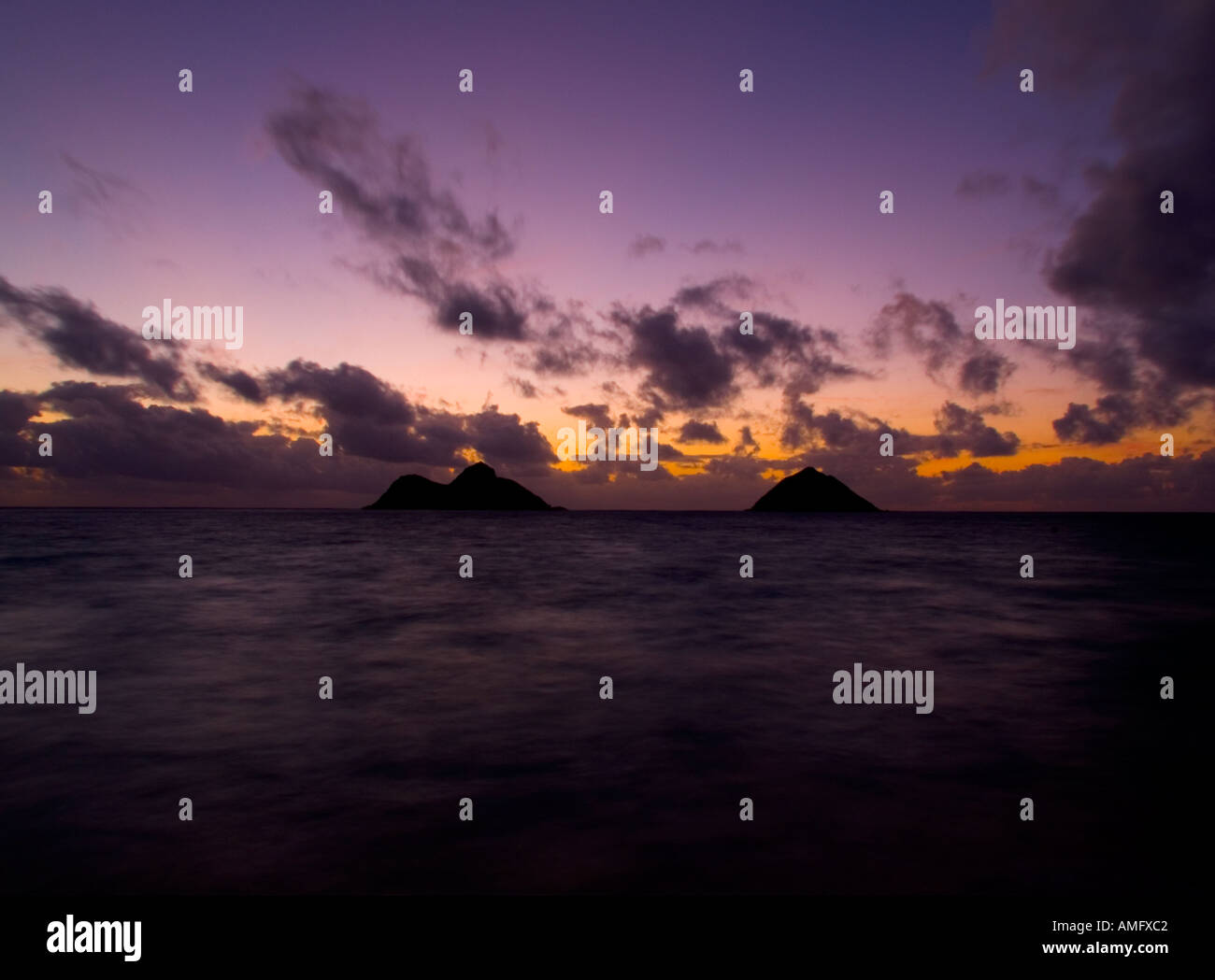 The sun rises slowly over the Mokulua islands in Hawaii USA Stock Photo ...