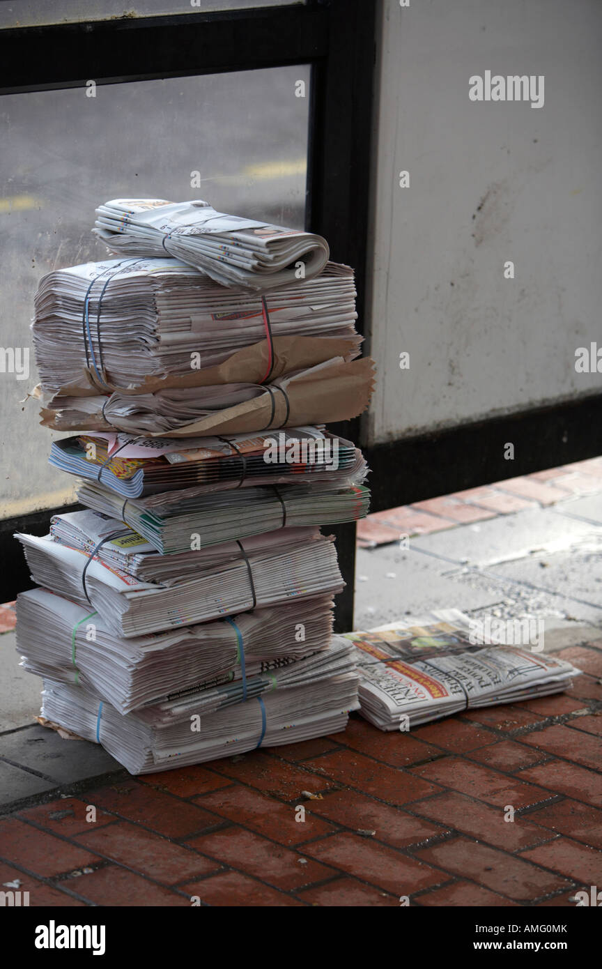 Pile of sunday newspapers wrapped up in bundles sitting under shelter ...