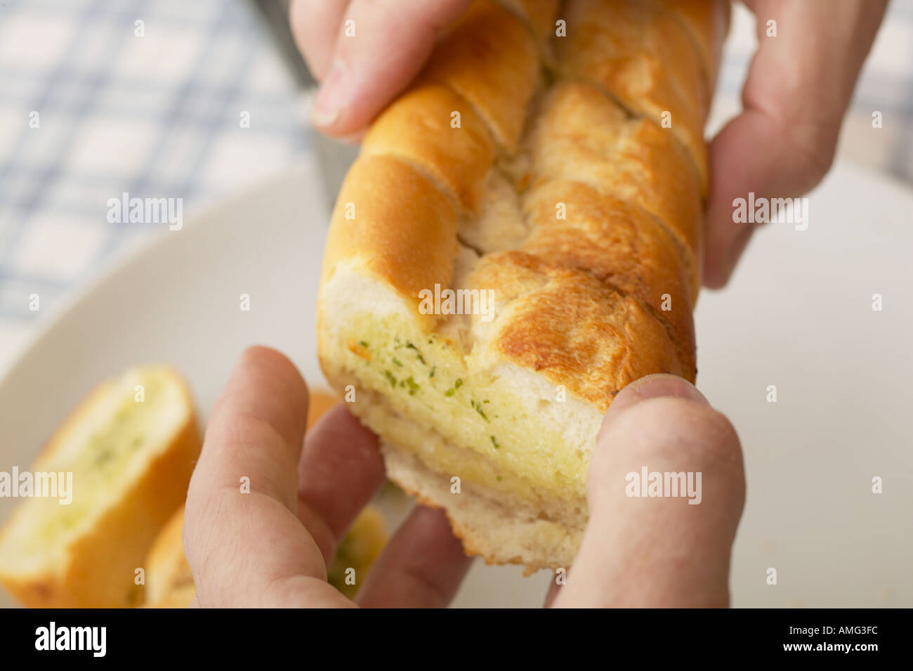 hand tearing slice of garlic bread Stock Photo - Alamy