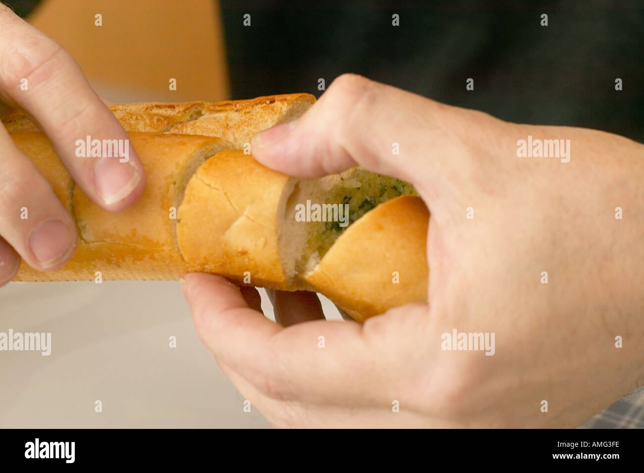 hand tearing slice of garlic bread Stock Photo - Alamy