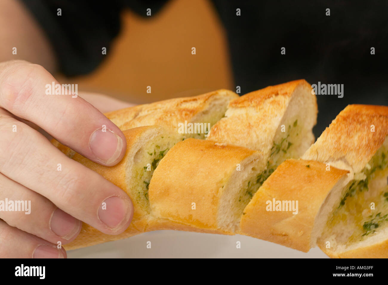 hand tearing slice of garlic bread Stock Photo - Alamy