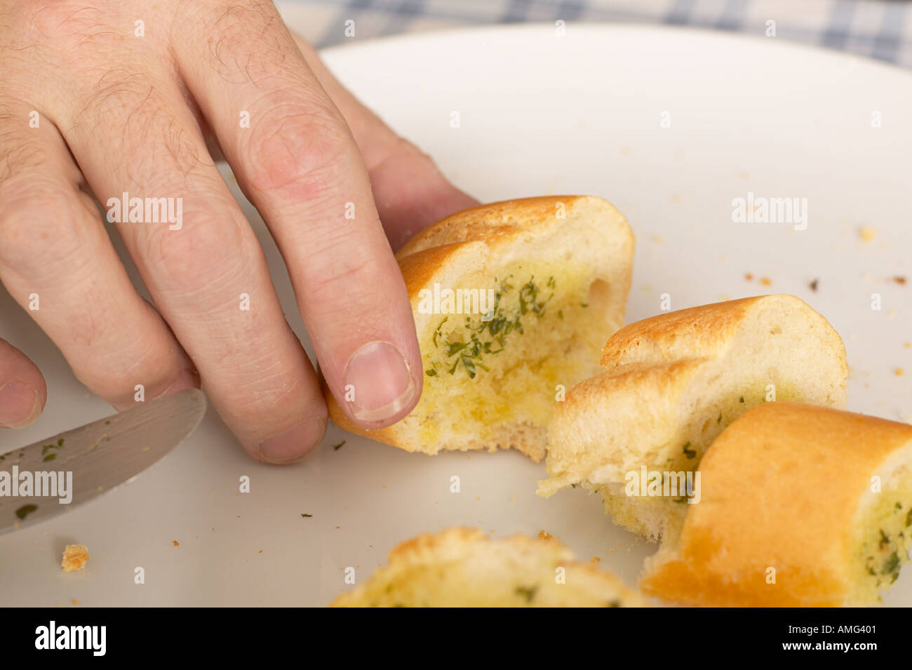 hand cutting slice of garlic bread with knife Stock Photo - Alamy